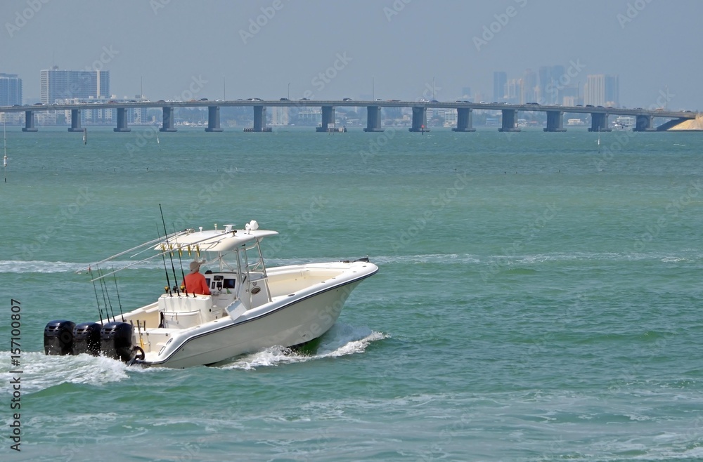 Sport fishing boat powered by three outboard engines cruising on the ...