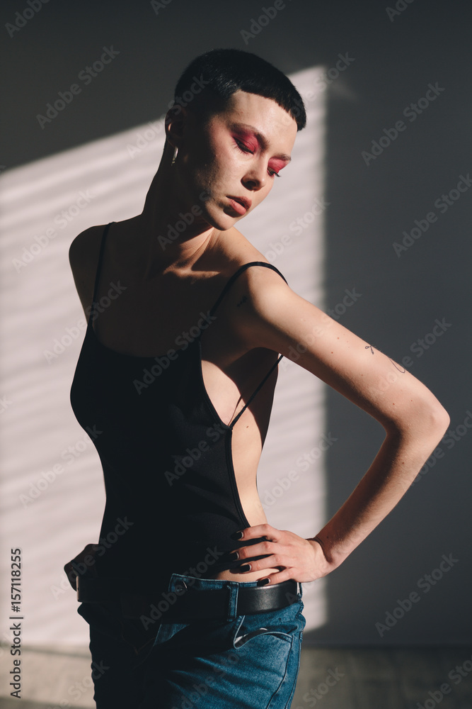 Attractive girl with perfect body and short hair posing in jeans in ...