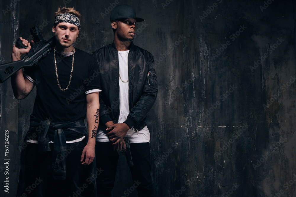 Foto Stock Group of young criminals with guns. Armed band of gangsters ... Foto Stock Group of young criminals with guns. Armed band of gangsters ...