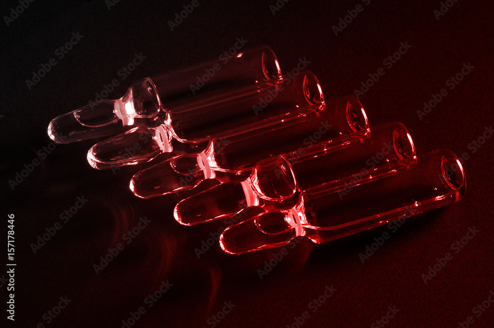 Row of ampulas with medicine on dark background Stock Photo | Adobe Stock