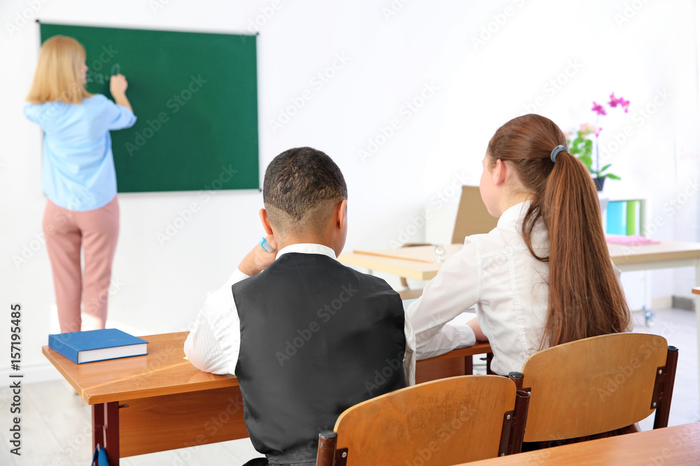 Pupils listening to teacher in classroom Stock Photo | Adobe Stock