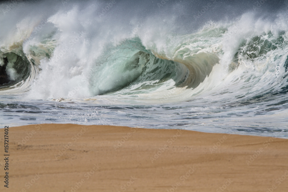 Shore break Ocean wave on the beach at Waimea Bay on the north shore of ...