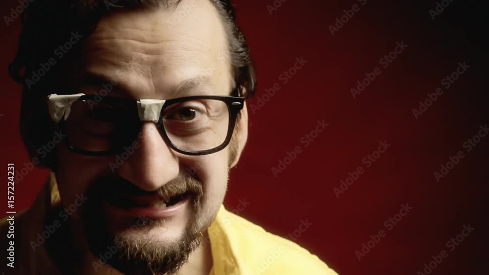 An angry ugly man wearing black broken eyeglasses (a stereotypical nerd ...