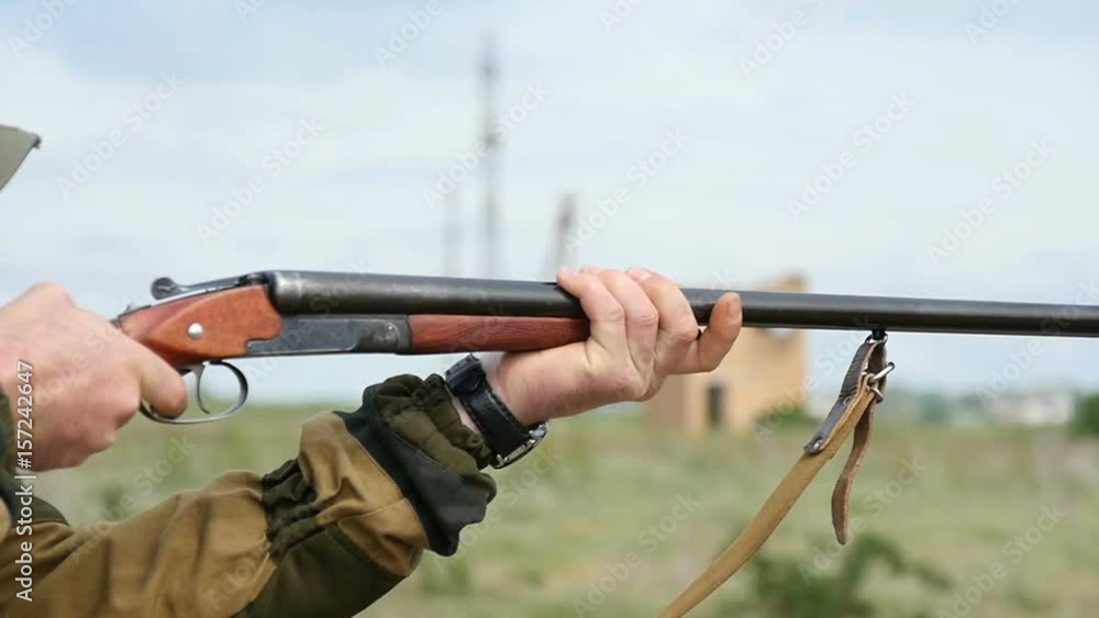 Amazing shot of a man aiming at some clay target while training skeet ...