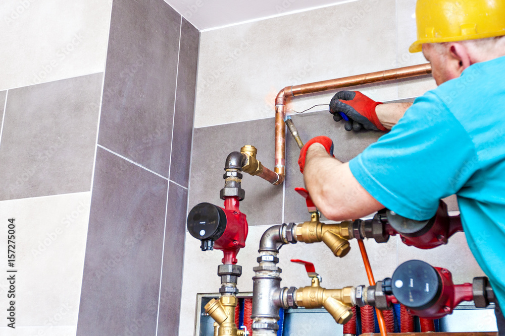 Plumber assembles the boiler room. Monter installs a central heating ...