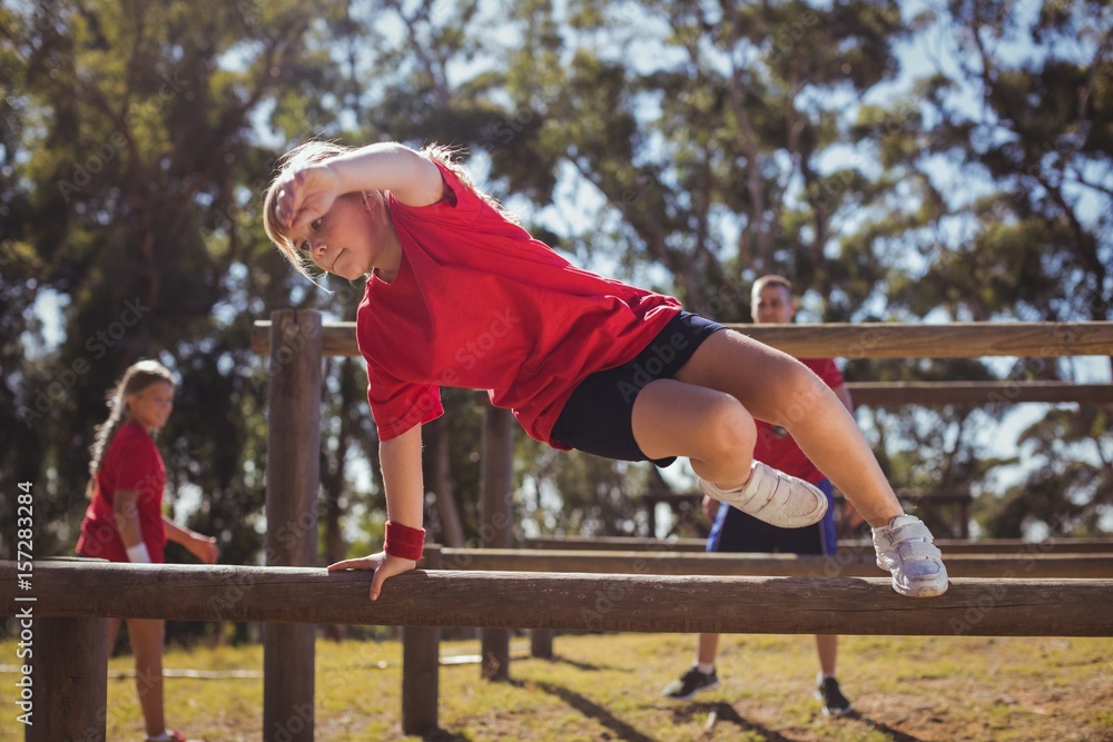 Kid jumping over the hurdles during obstacle course training Stock ...