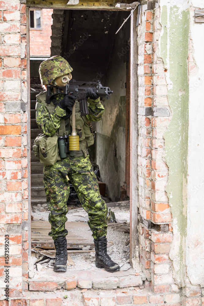 Portrait of armed woman with camouflage. Young female soldier observe ...