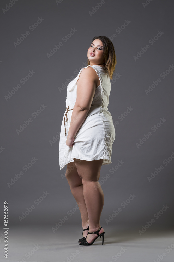 Plus size fashion model in casual clothes, fat woman on gray background ...