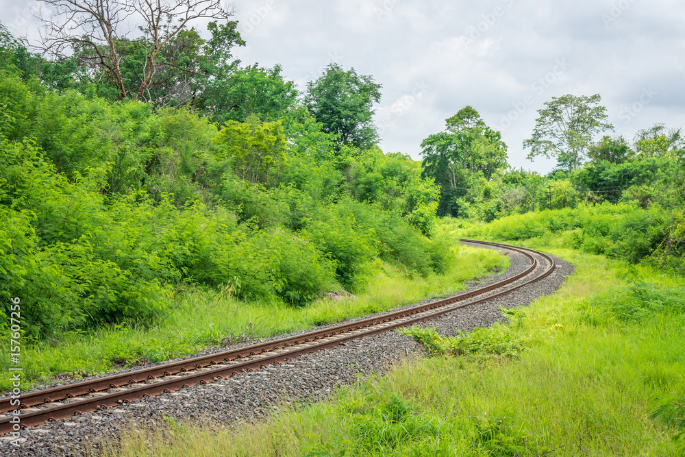 Curved single train track in forest of Thailand. With two parallel iron ...