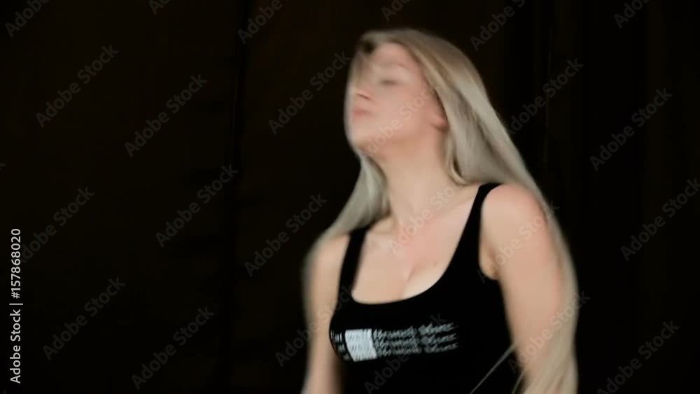 A blonde girl woman with very long hair dances go-go. Close-up ...