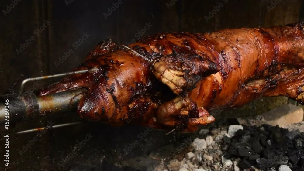 Pig is roasting on a spit. Roasting pig is prepared for festivities to ...
