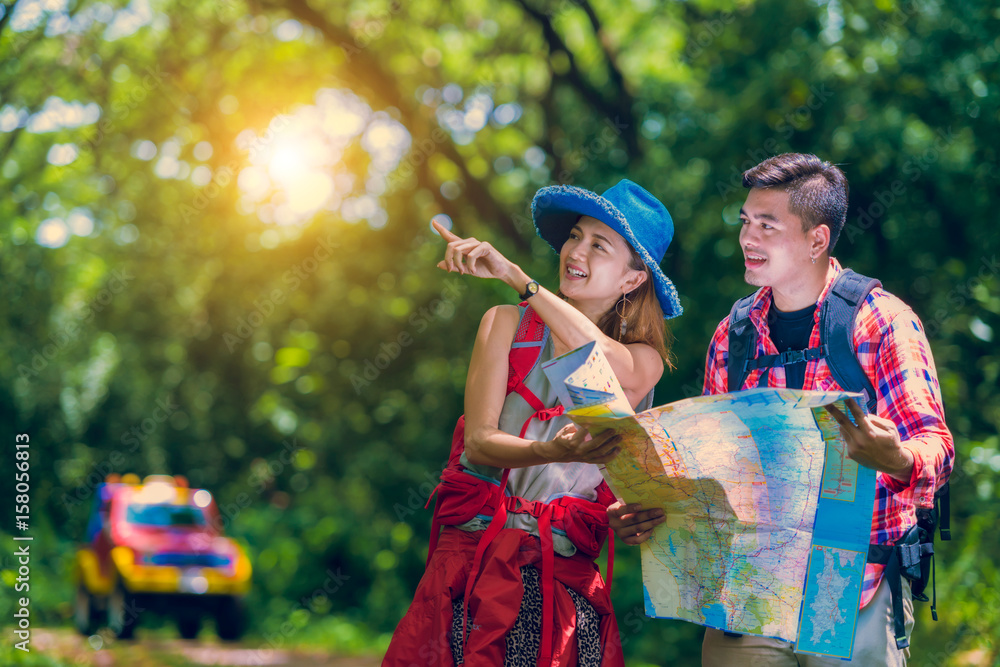 Asian couple for a new adventure looking for the right way on the map ...