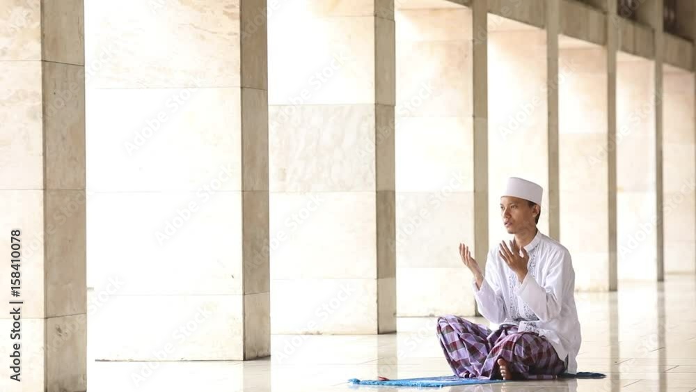 Religious muslim man sitting on the mosque while wearing islamic ...