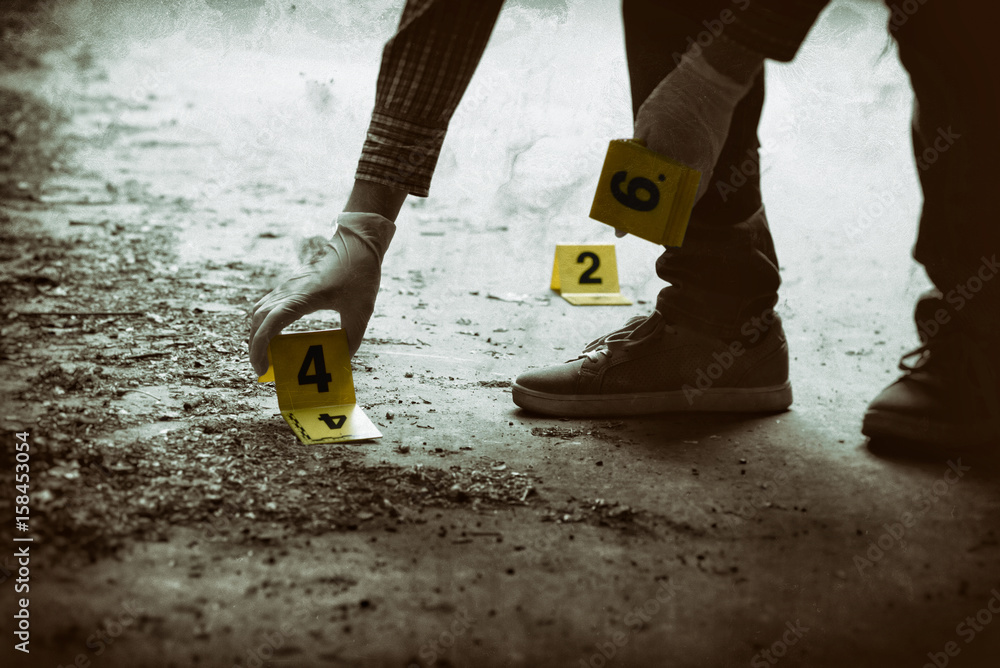 Putting the crime scene marker on the ground Stock Photo | Adobe Stock