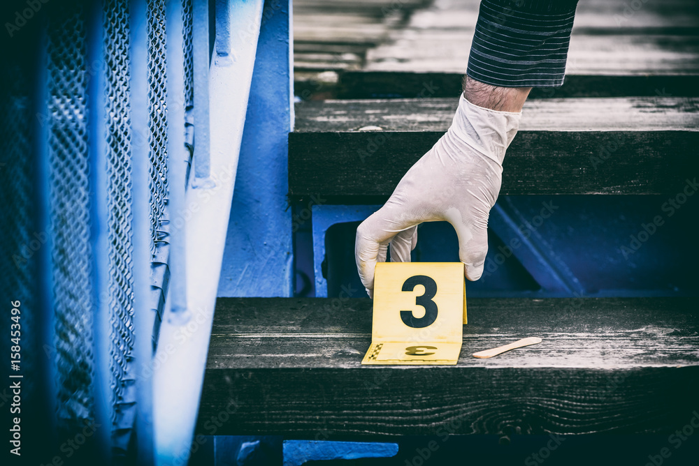 Crime scene investigation, putting the crime scene marker on wood ...