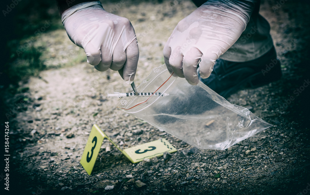 Foto de Crime scene investigation, picking up the tossed syringe and ...