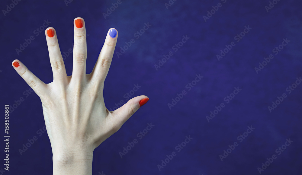 One different nail color in finger in caucasian hand. Red and blue ...