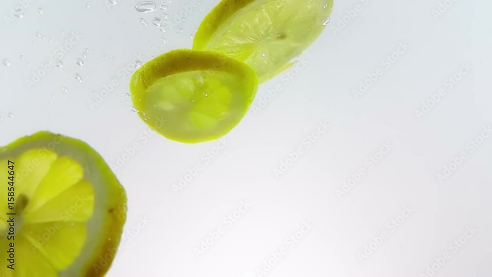 lemon slice fruit splash falling down into white alcohol cocktail and ...