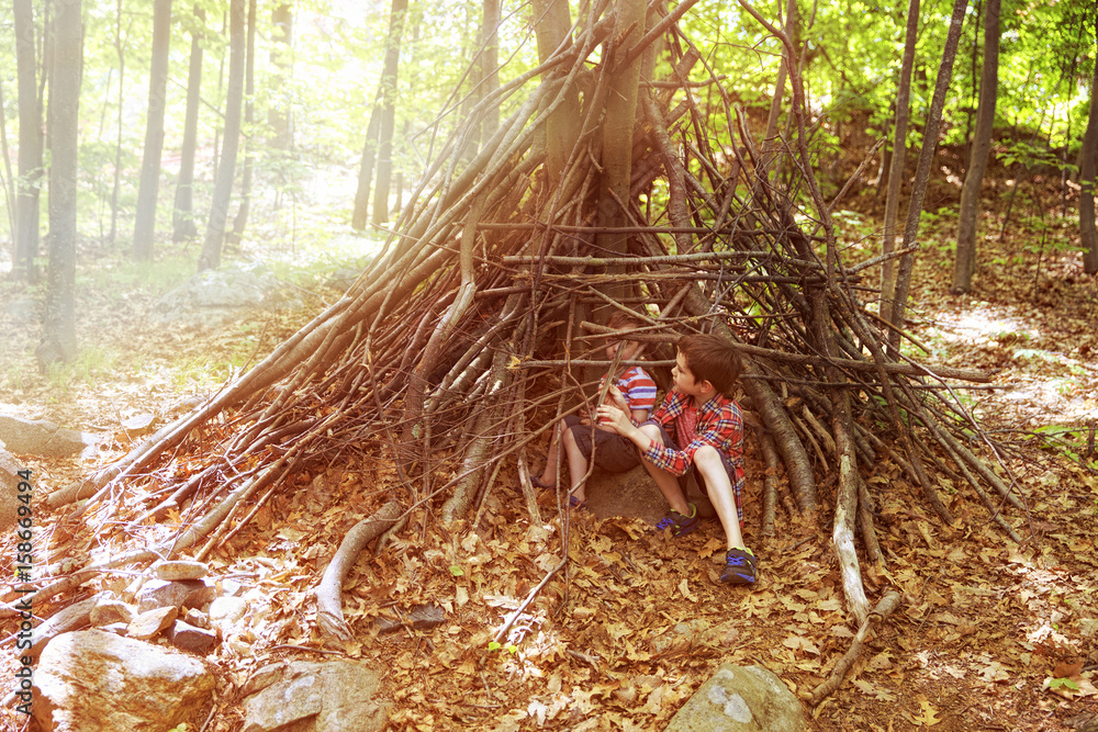 Children play in a hut out of twigs. wooden stick hut house in the ...