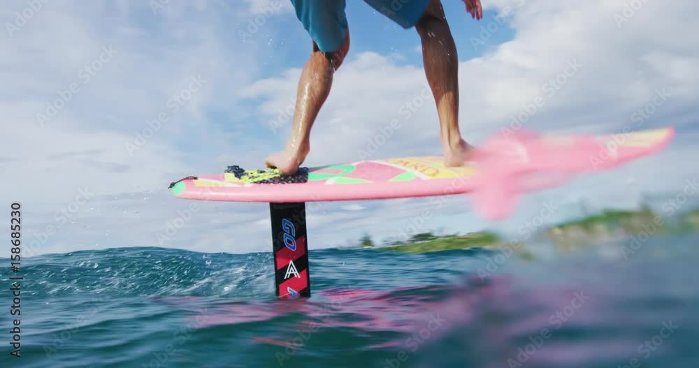 Surfer on hydrofoil surfboard riding blue ocean wave. Futuristic ...
