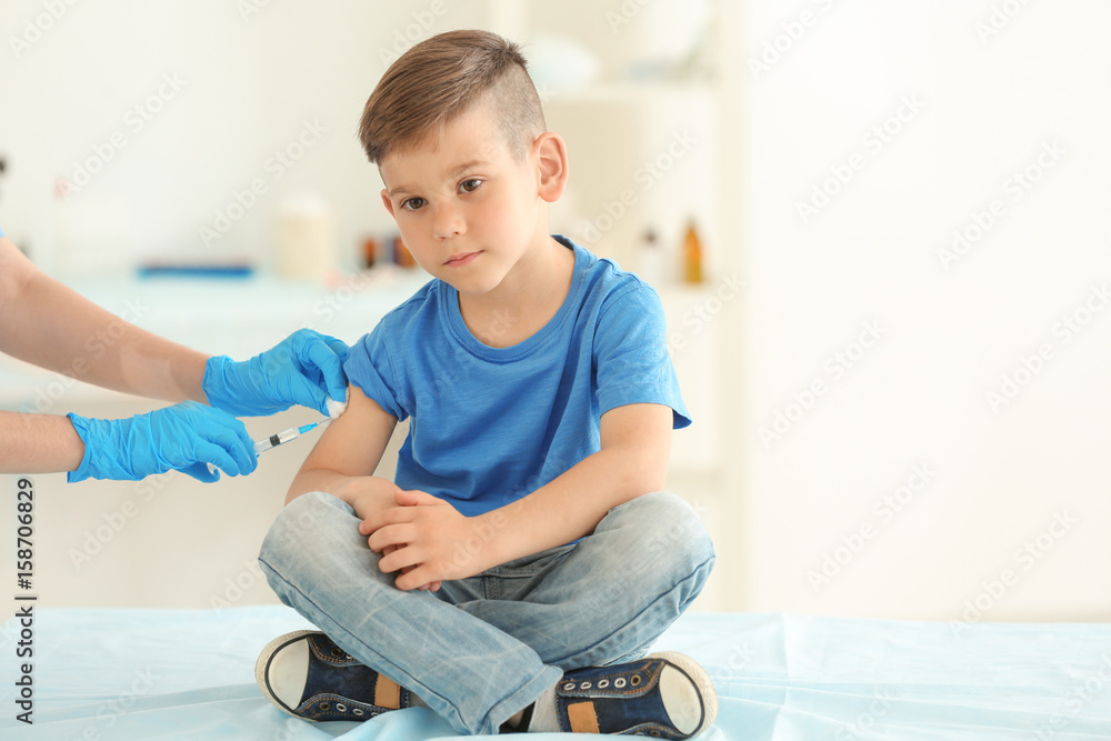 Vaccination concept. Female doctor vaccinating cute little boy in ...