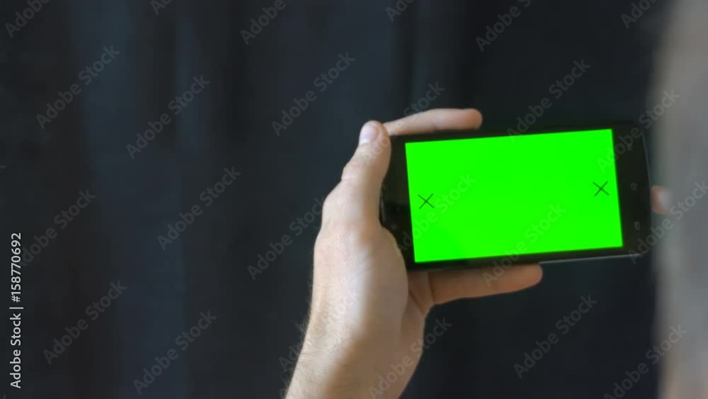 Close-up of male hands touching of smartphone. Green screen Chroma Key ...