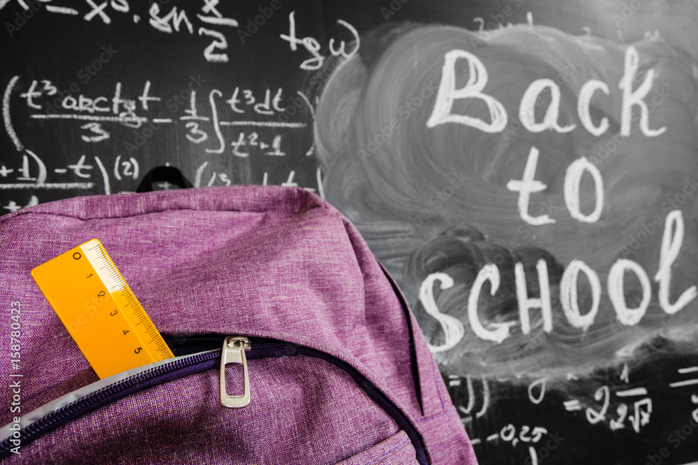 Back to school background with purple school bag with yellow ruler and ...