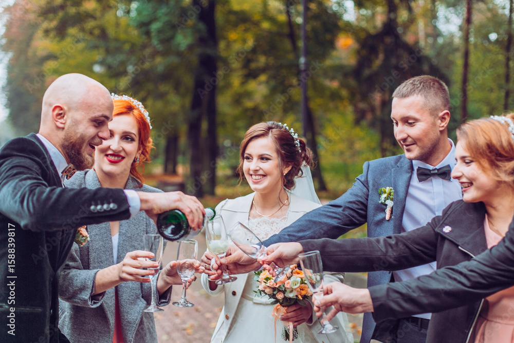 bride and groom with happy groomsmen and bridesmaids having fun and ...
