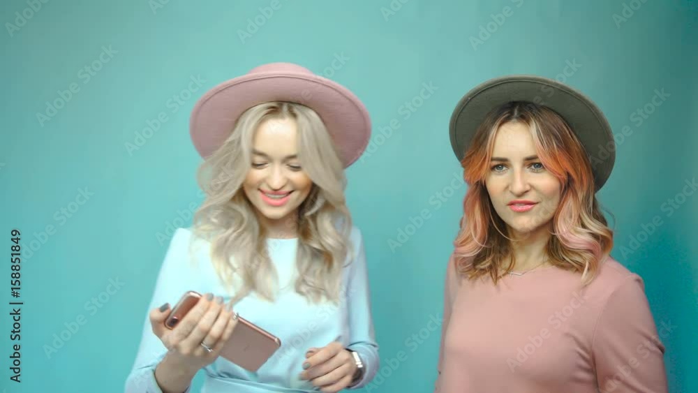 Two similar girls in hats and dresses are photographed in a ...