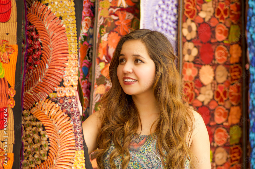 Close up of a beautiful smiling young woman touching andean traditional ...
