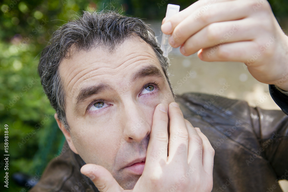 Man using eye drops Stock Photo | Adobe Stock