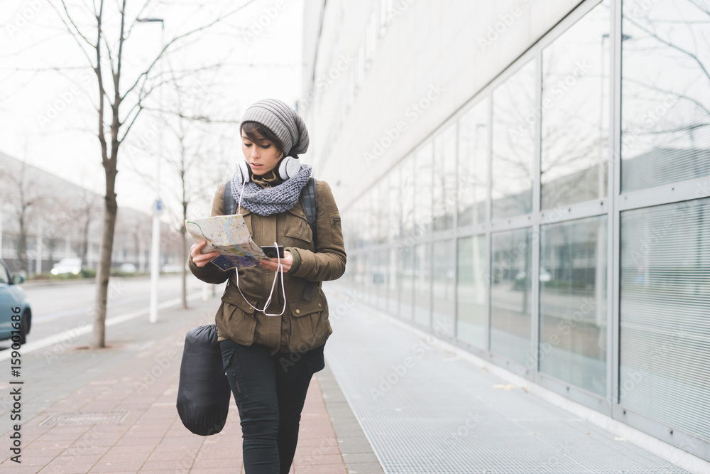 Female backpacker with smartphone looking at map on city sidewalk Stock ...