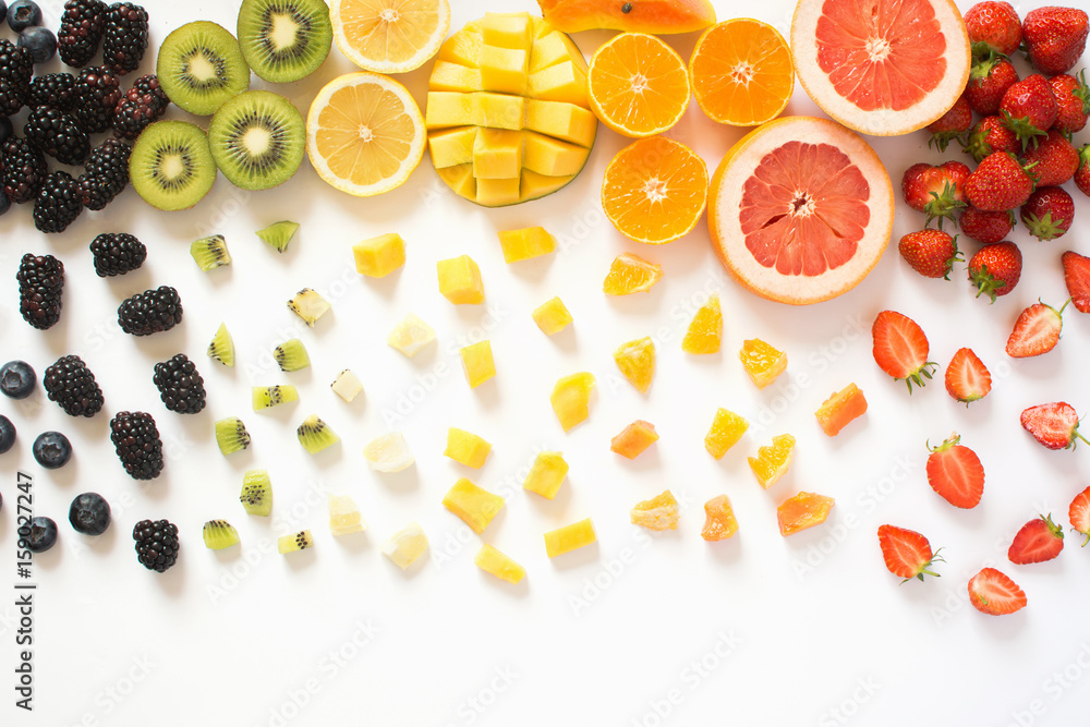 Top view of whole fruits and cut slices in the rows, red, orange ...