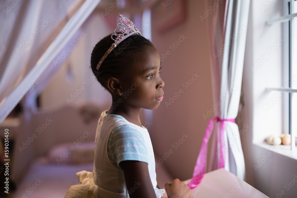 Side view of thoughtful girl wearing crown standing in bedroom Stock ...