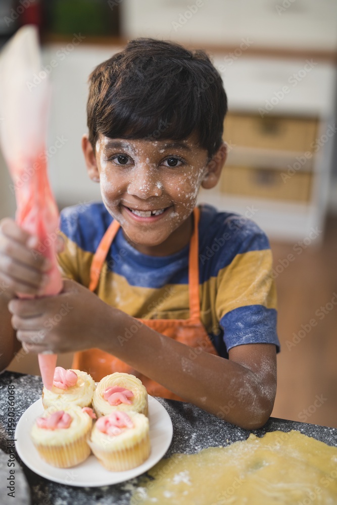Portrait of happy boy making cup cakes in kitchen Stock Photo | Adobe Stock