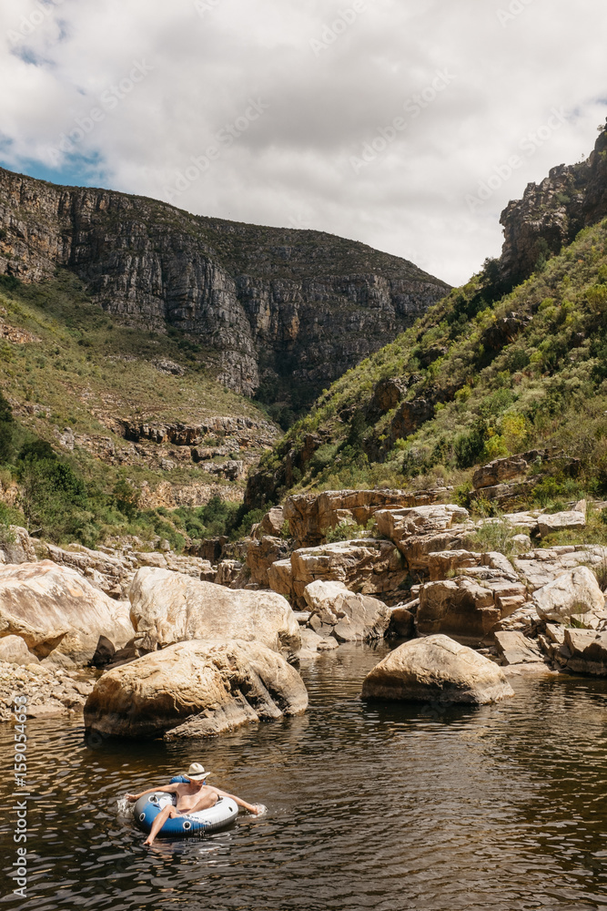 Man floating on an inflatable tube in a river or lake Stock Photo ...