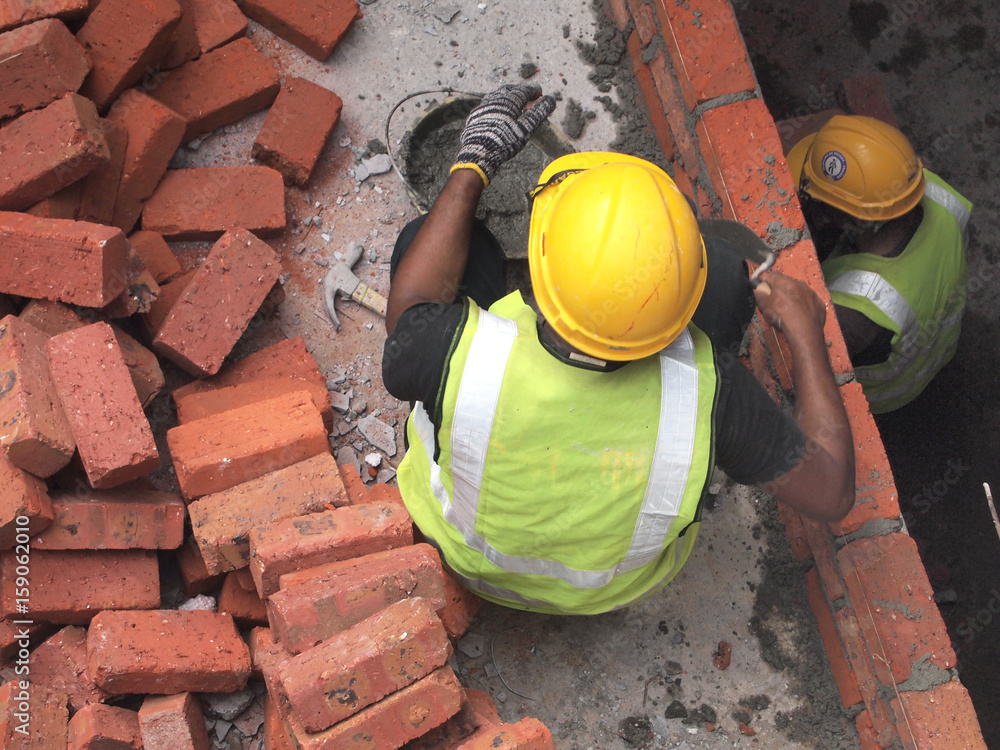 Bricklayer lay clay bricks block to form building walls at the ...