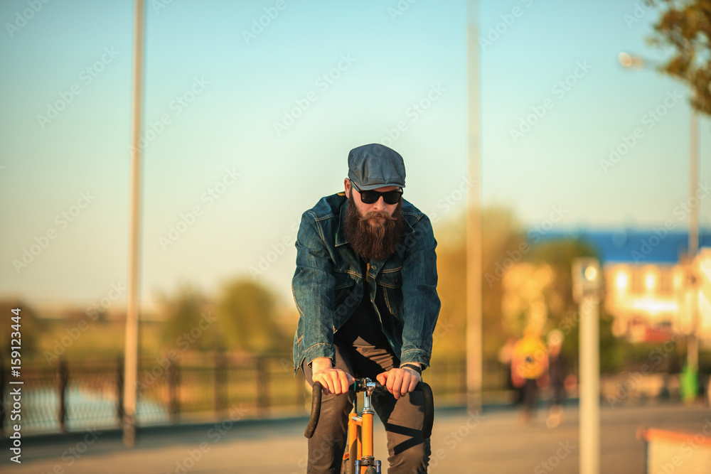 Bearded guy and fix bike. Young man with gourgeous large beard in ...