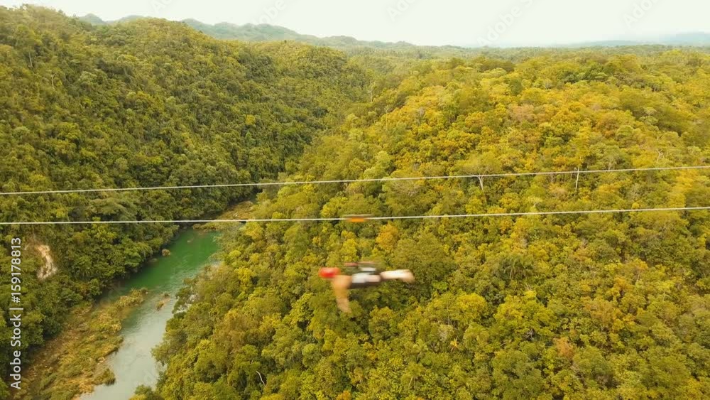 Video „People have fun a zip line through a canyon with a river in the ...