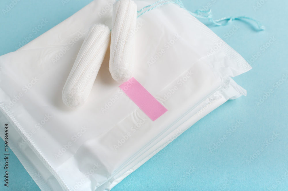 Menstrual tampons and pads on a blue background. Menstruation time ...
