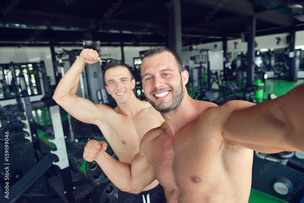 Portrait of two smiling muscular men flexing biceps Stock Photo | Adobe ...