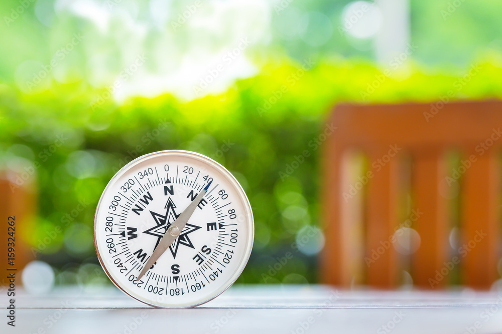compass on table with nature blurred background, find the right ...