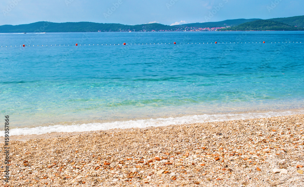 Pebble sandy beach on the background of a hill range with many small ...