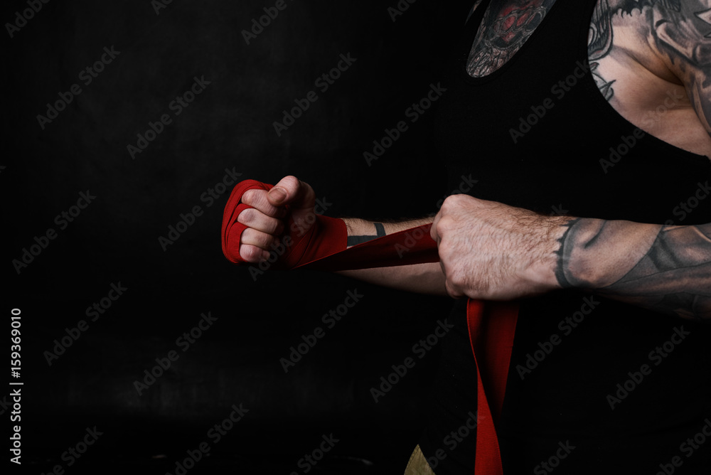 Fighting concept. Brutal tattooed hands with red bandage ready for a ...