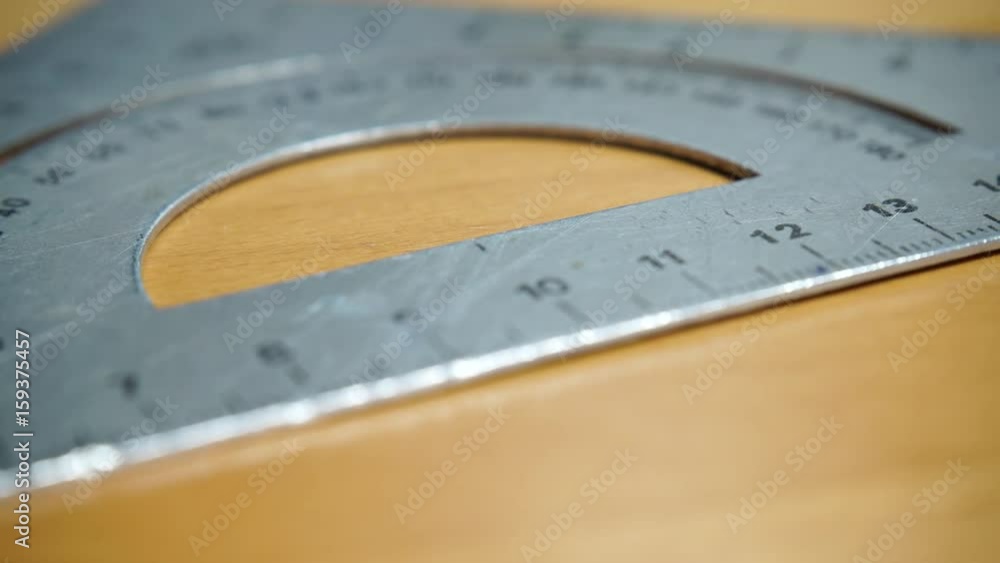 Old metal protractor ruler and set square on wooden table background ...