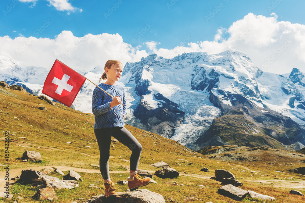 Cute little girl holding swiss flag, standing in front of Gornergrat ...