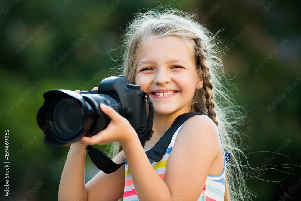 little girl with camera outdoors. Stock Photo | Adobe Stock