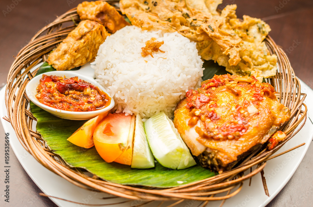 set of menu contain rice, cucumber, fried chicken, tomato, chili sauce ...