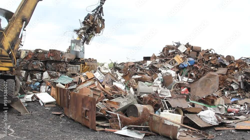 Sorting and loading of scrap metal. / Excavator is loading scrap metal ...