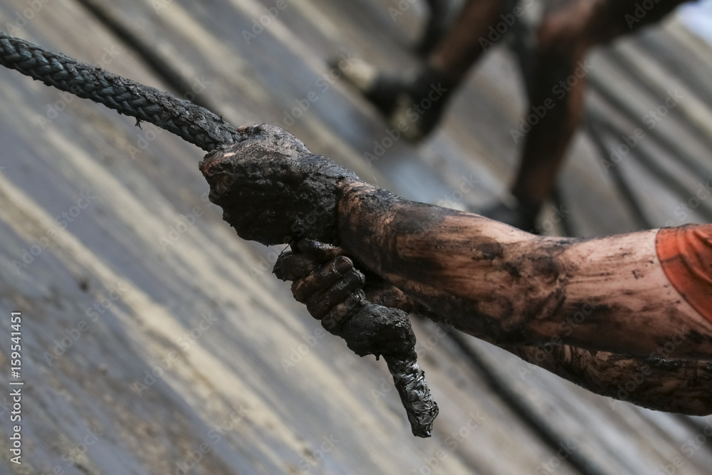 Mud race runners,participant for overcoming barriers through ropes ...